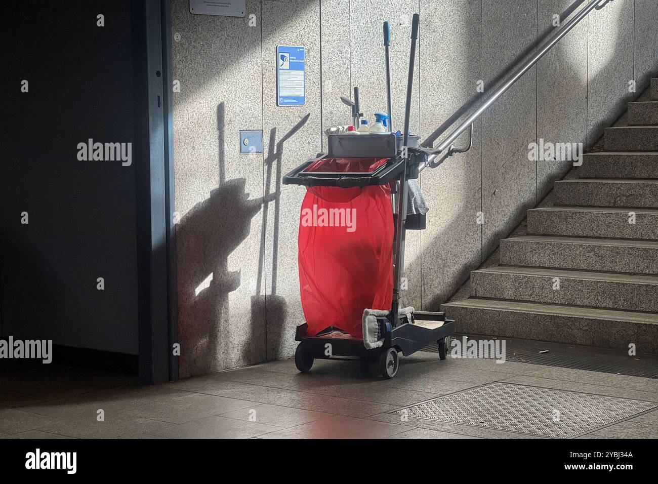 Putzwagen einer Reinigungskraft im steht vor einer Treppe am U-Bahnhof ...