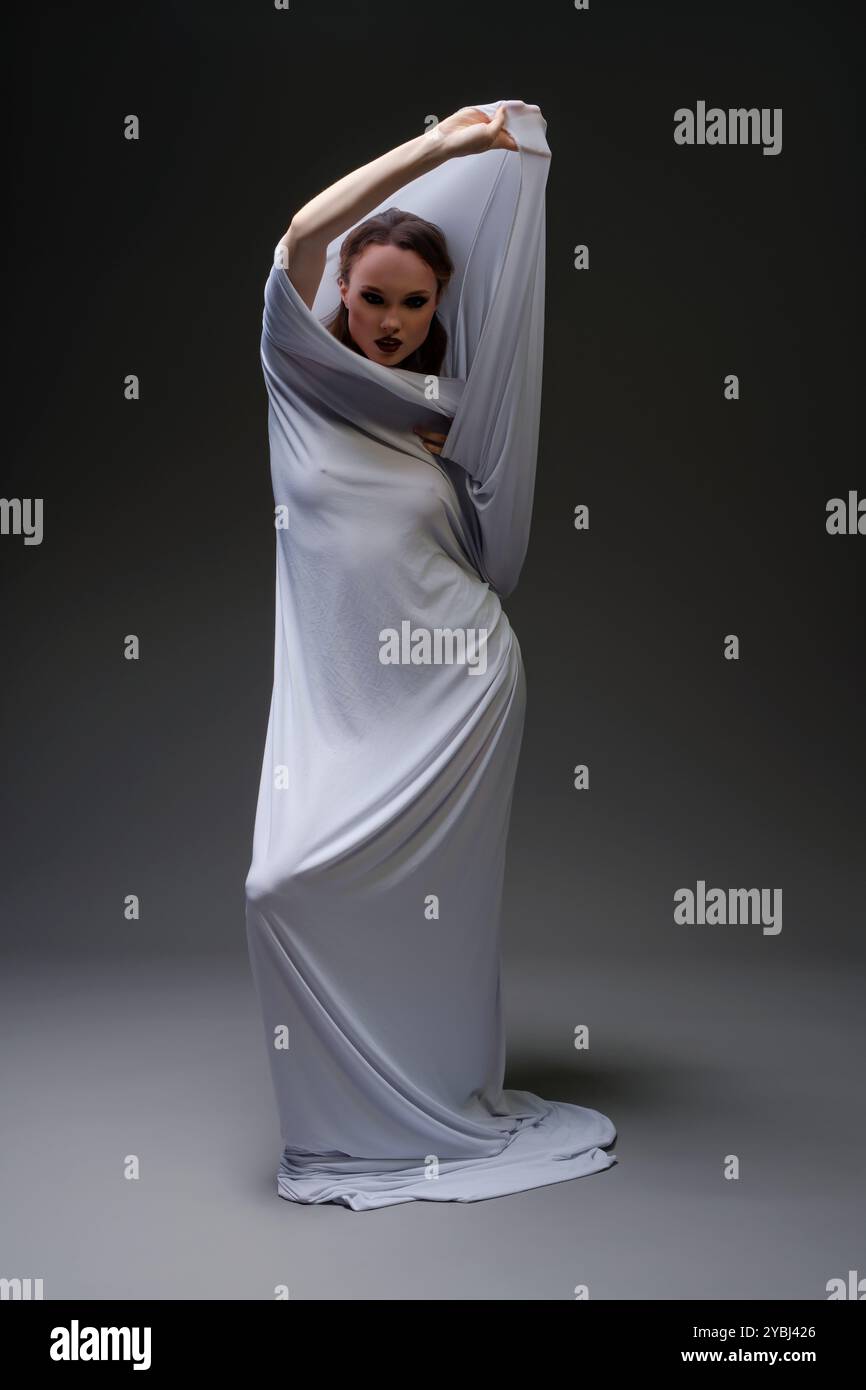Elegant model performing expressive movement in flowing fabric on a ...