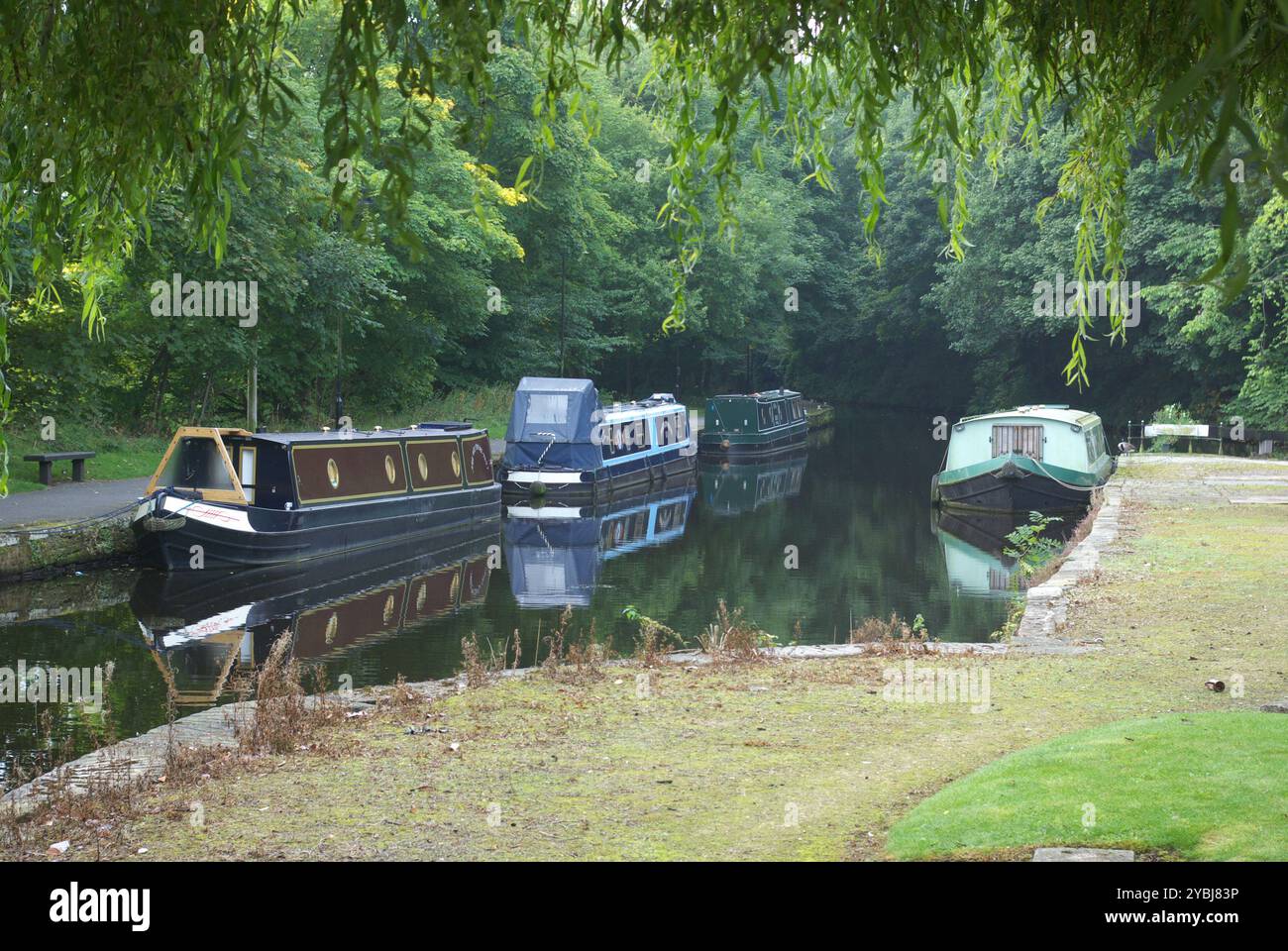Canal boats reflecting in the water on the Calder and Hebble Navigation ...