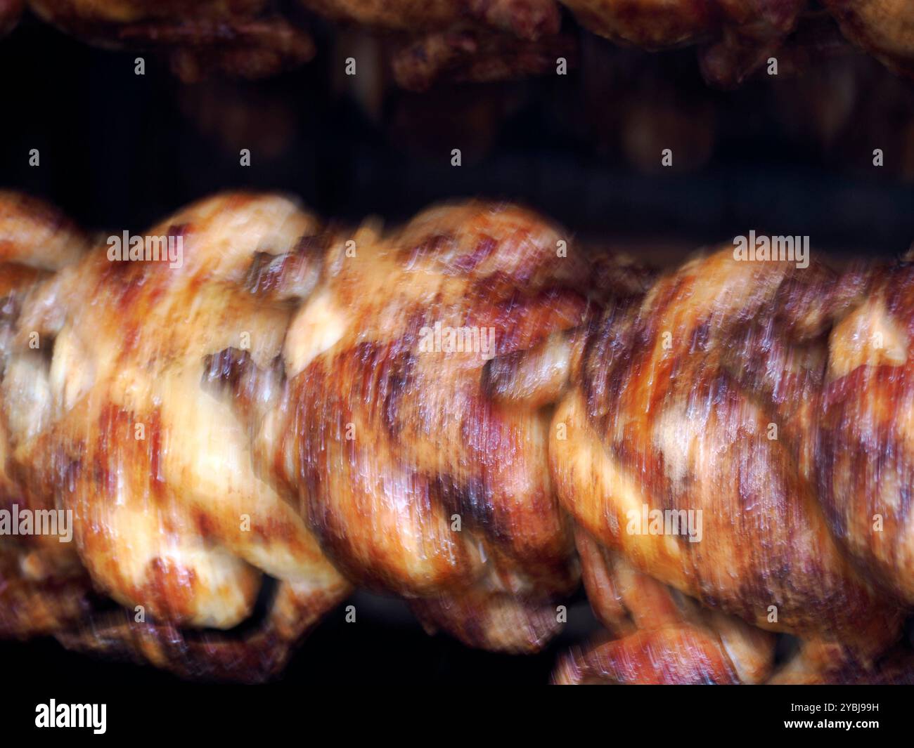 many chickens on the rotisserie Close-up shot of a steamy rotisserie ...