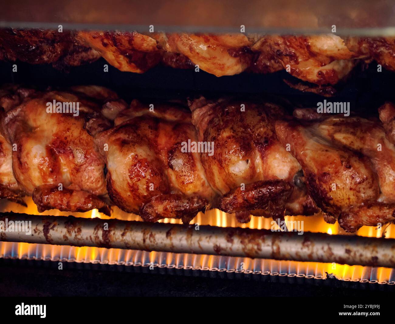 many chickens on the rotisserie Close-up shot of a steamy rotisserie ...