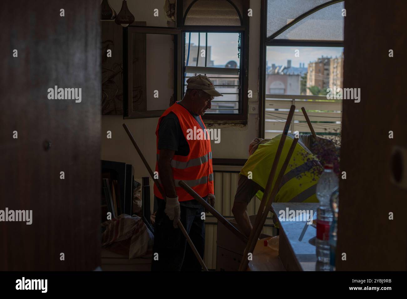 Kiryat Ata, Israel. 19th Oct, 2024. Workers clean the debris after a ...
