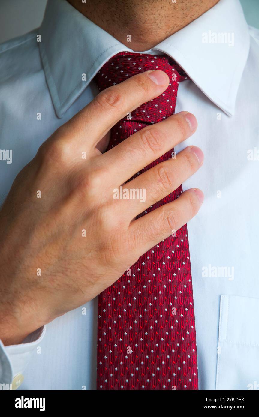 Man tying his tie. Close view Stock Photo - Alamy