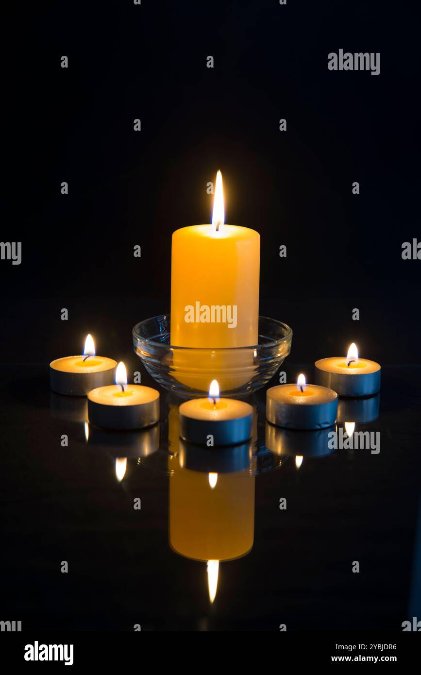 Lit up candles and their reflection on glass Stock Photo - Alamy