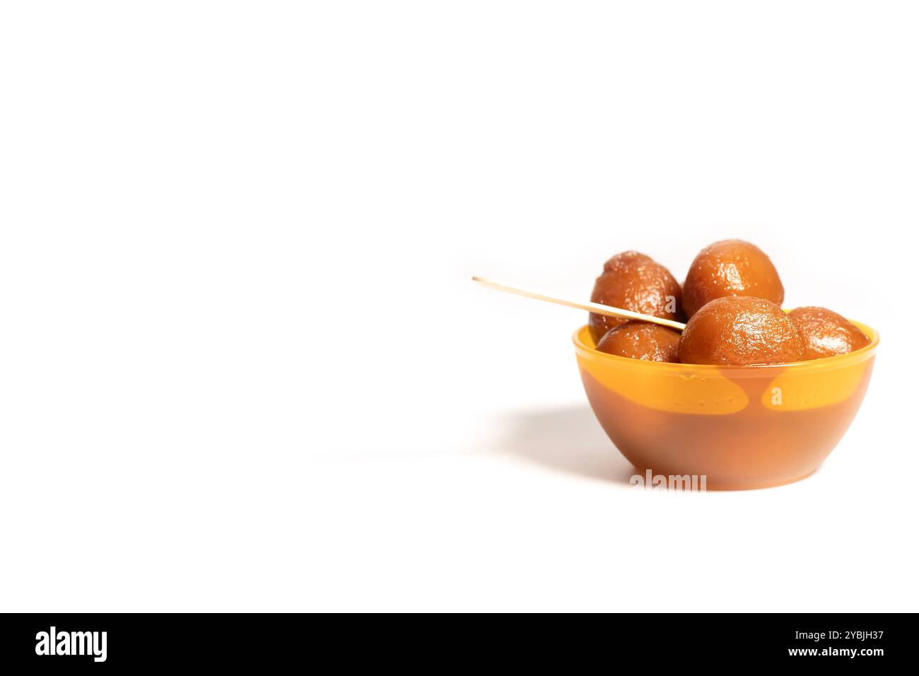 Traditional Indian Gulab Jamun sweet balls in orange bowl with wooden ...