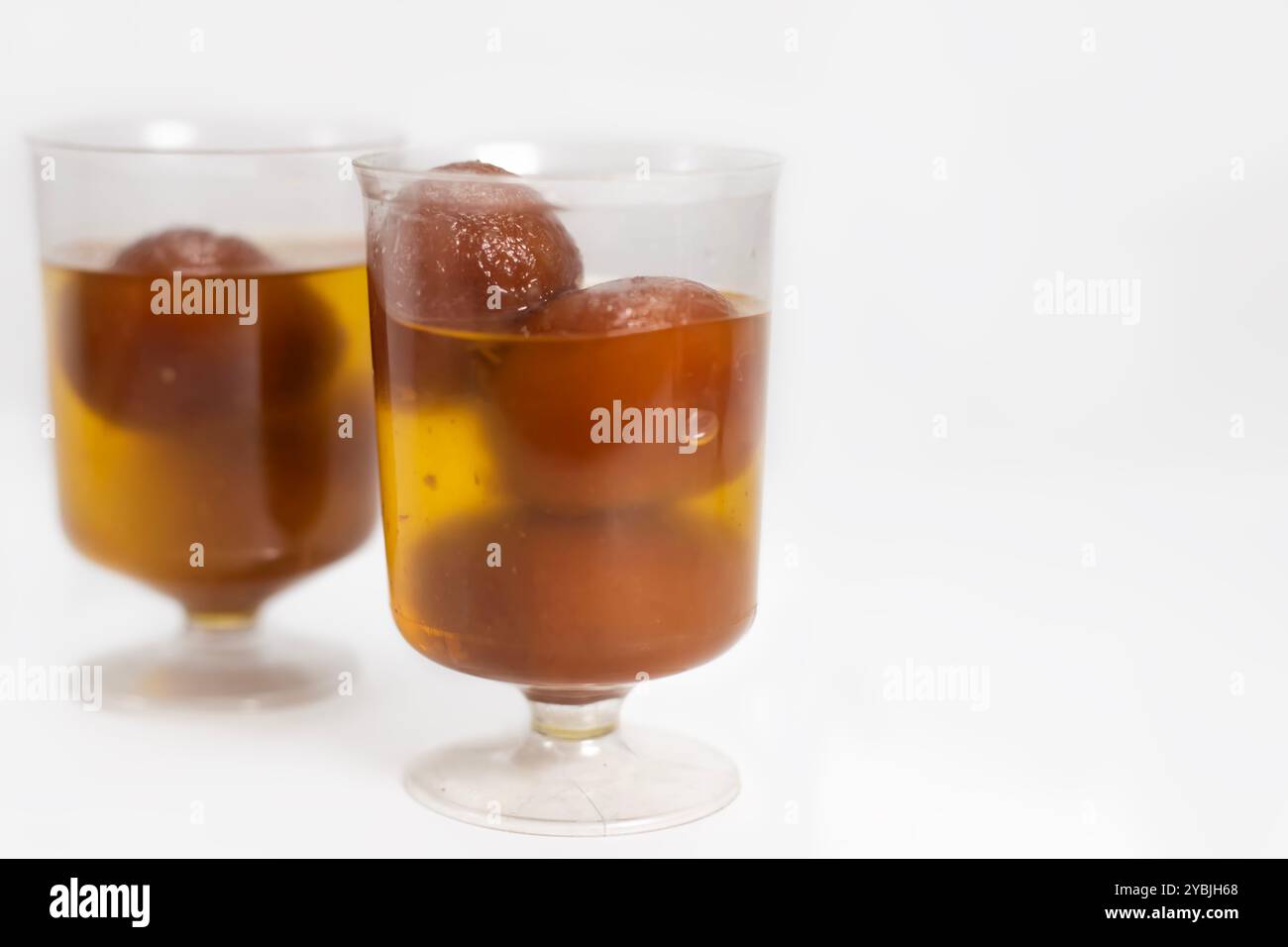 Indian sweet Gulab Jamun served in transparent glass cups on white ...