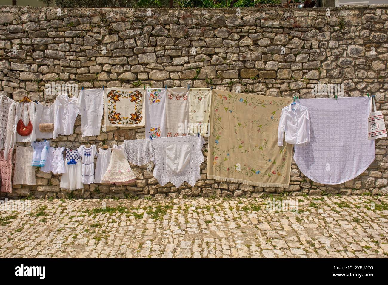 Souvenir clothes and tablecloths hanging from the fortified walls of ...