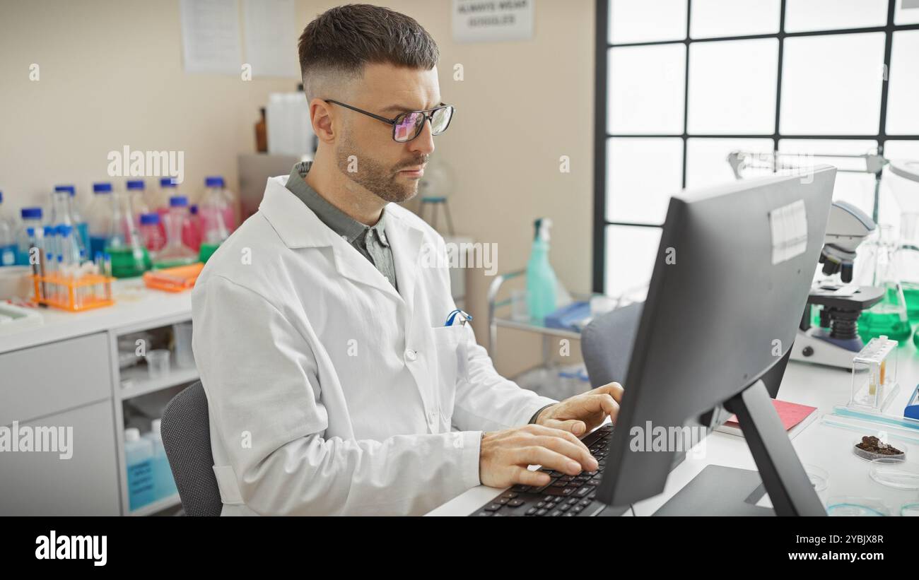 Handsome hispanic man in lab coat working on computer in a modern ...