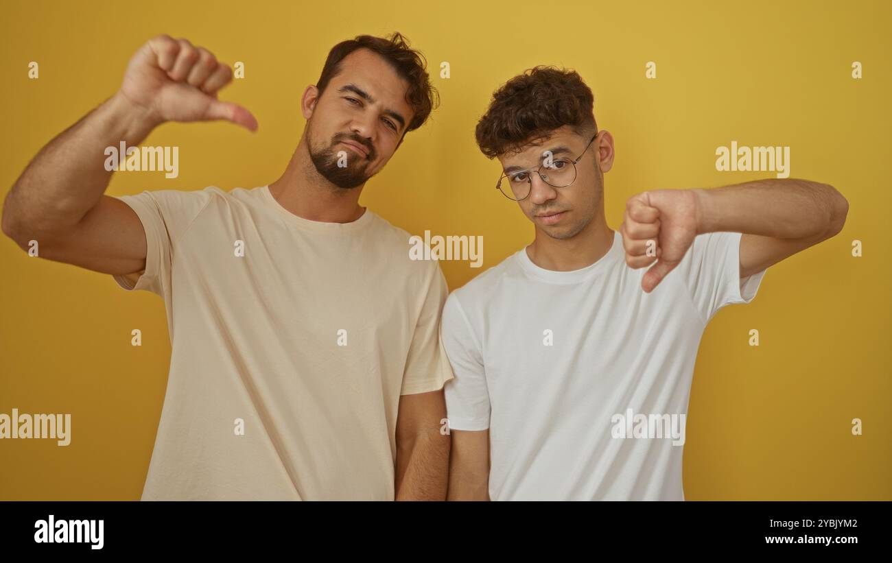 Father and son expressing disapproval together against a yellow wall ...