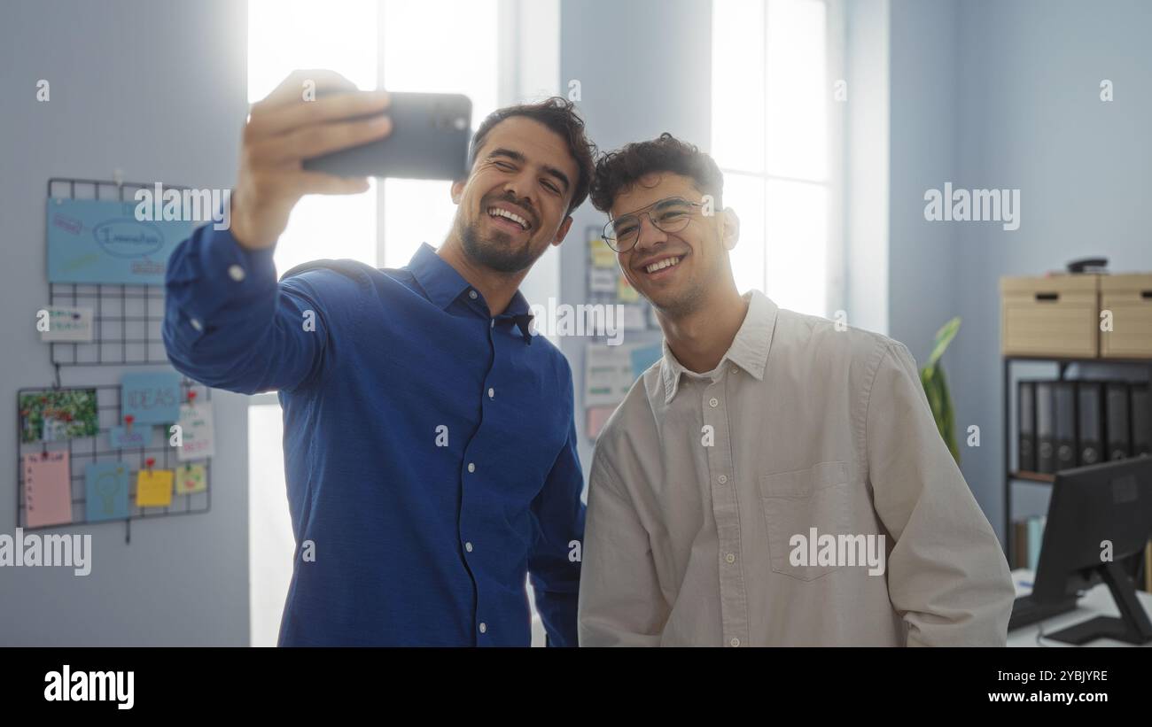 Men taking selfie together in a modern office setting, showcasing ...