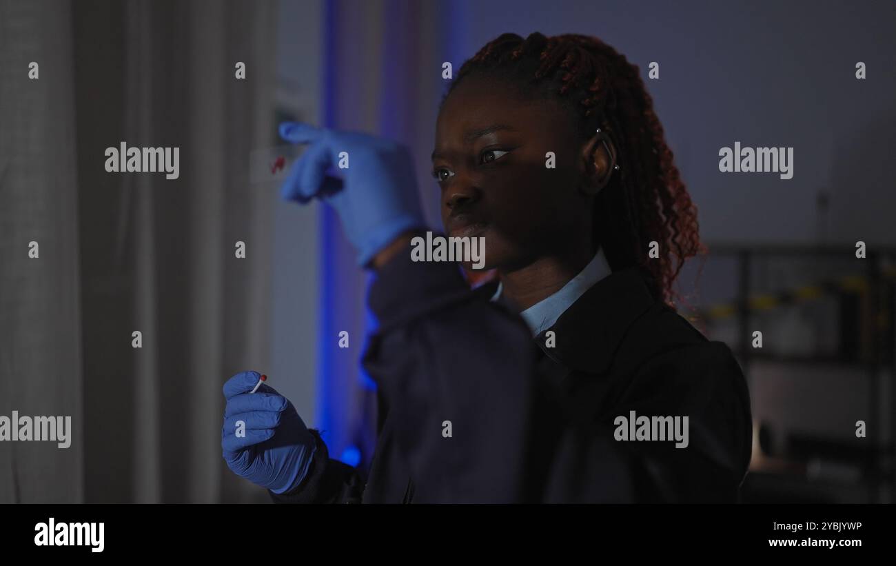 African american woman detective analyzing evidence at indoor crime ...