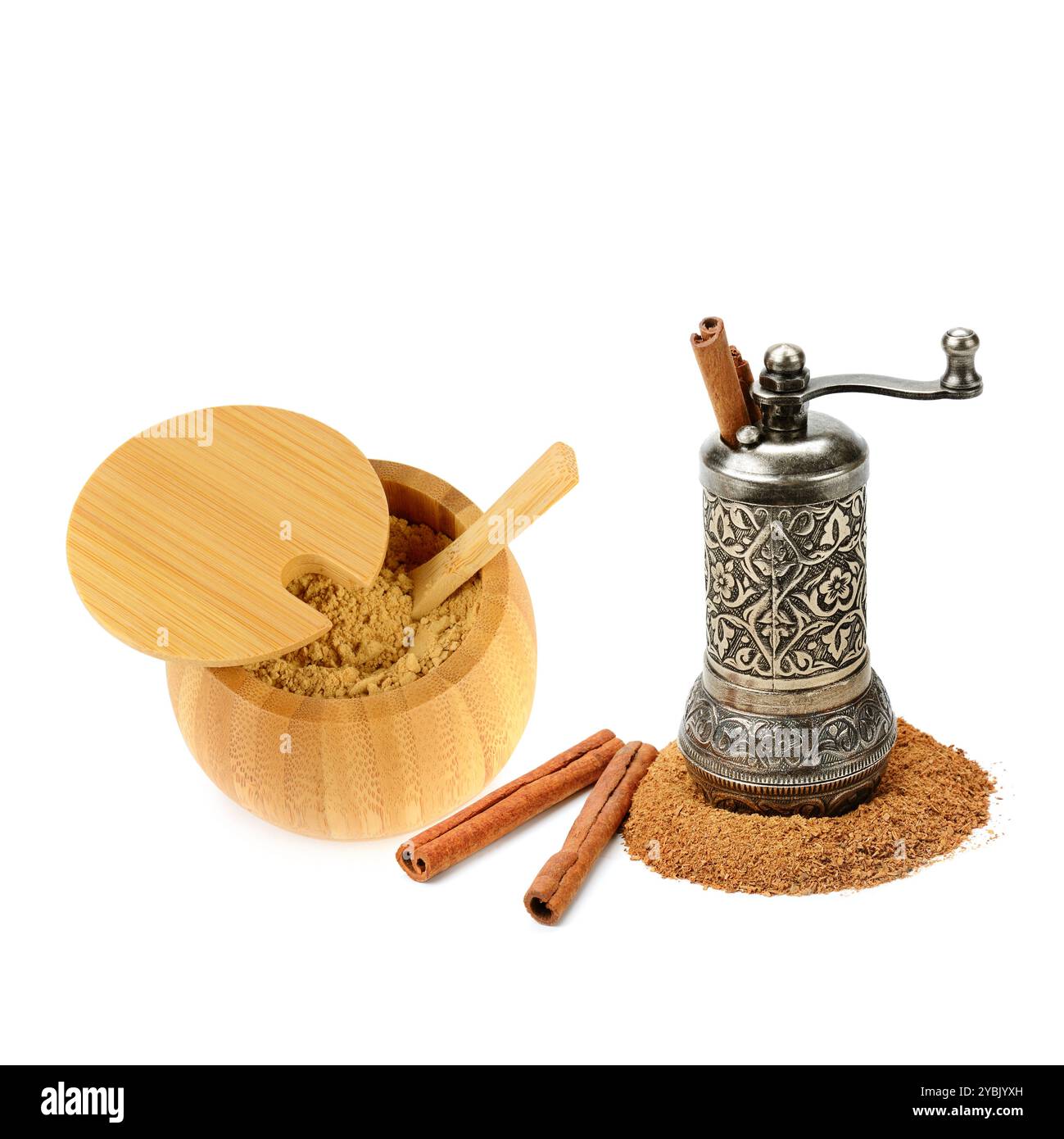 Hand grinder, cinnamon sticks and powder, Curry spice in wooden bowl ...