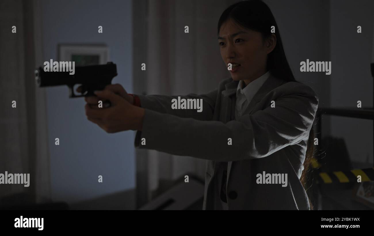 An intense scene with an asian woman aiming a handgun in a dark, dimly ...