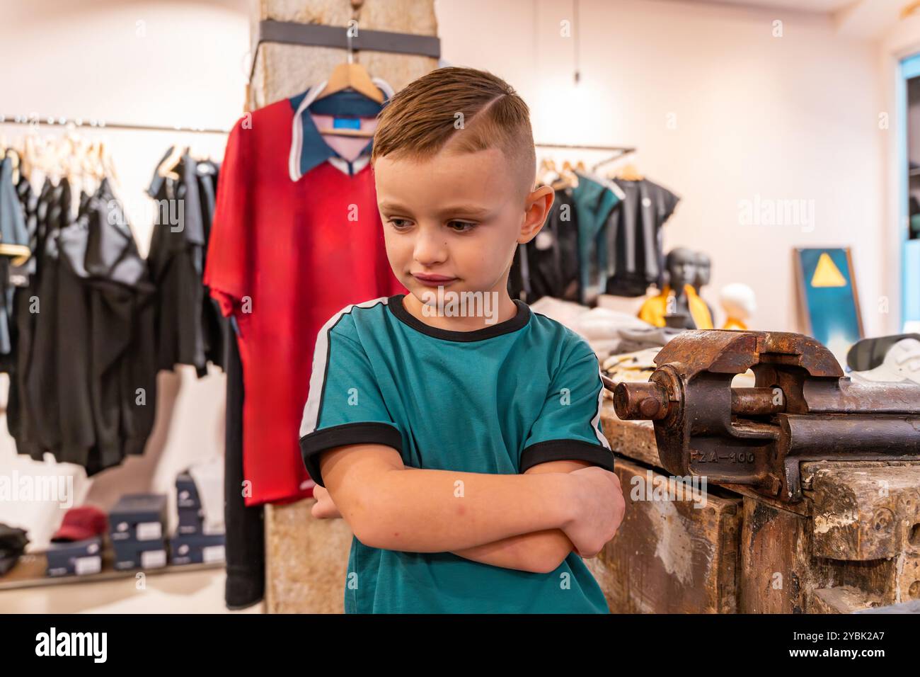young expressive child having fun posing as a model in a clothing store ...