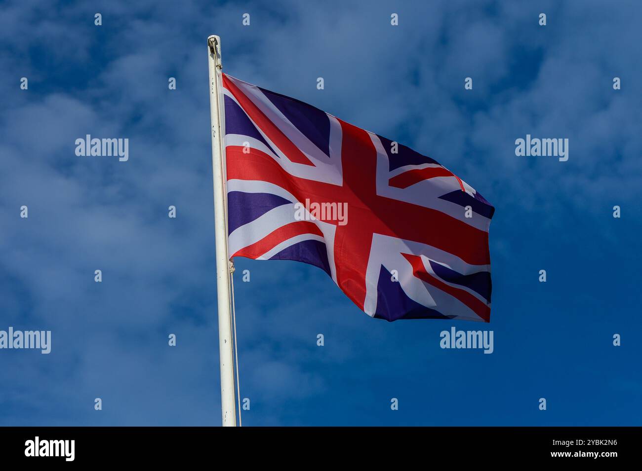 The Union Jack is seen fluttering against a backdrop of clear blue ...