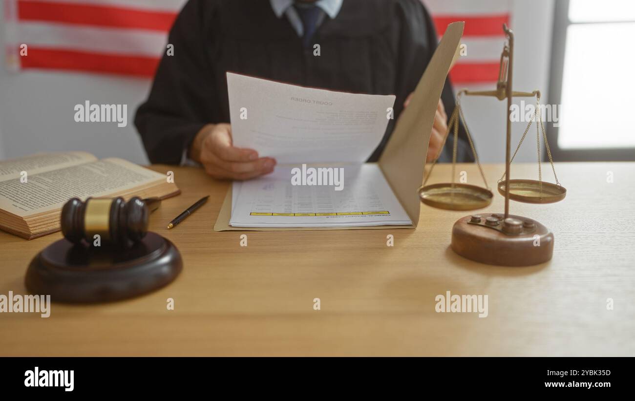 Male judge in courtroom reviewing documents with gavel and scales of ...