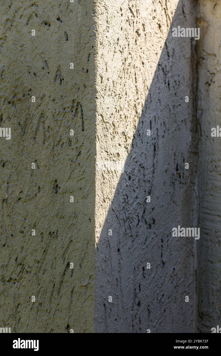 A strong beam of sunlight creates a bold contrast against the textured ...