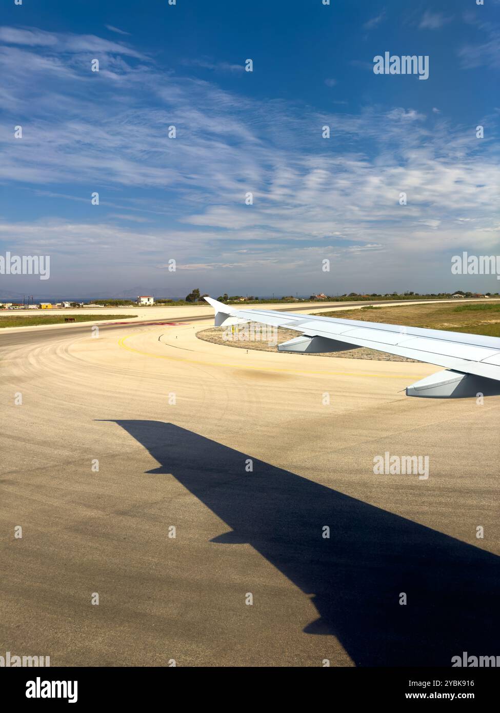 Landing Airplane Wing Casting a Shadow on the Runway Under a Bright Sky ...