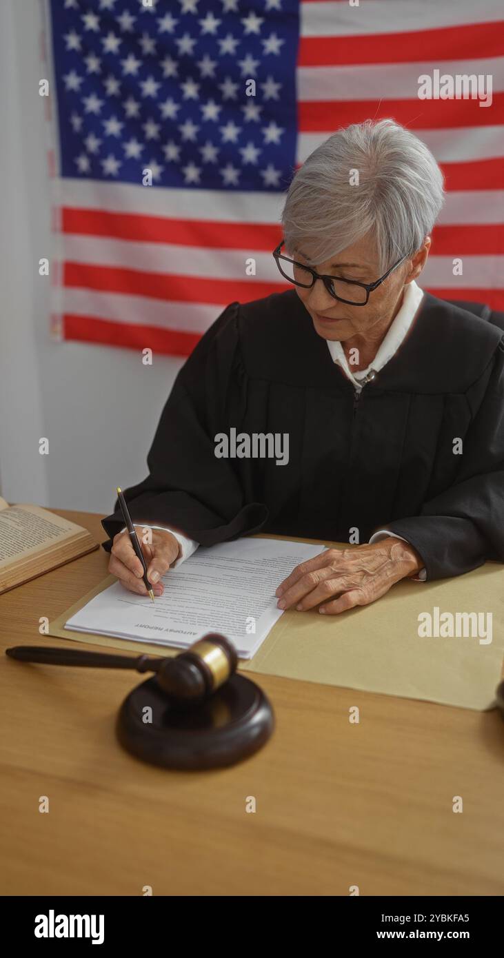 Mature woman judge with short grey hair signing documents in an ...