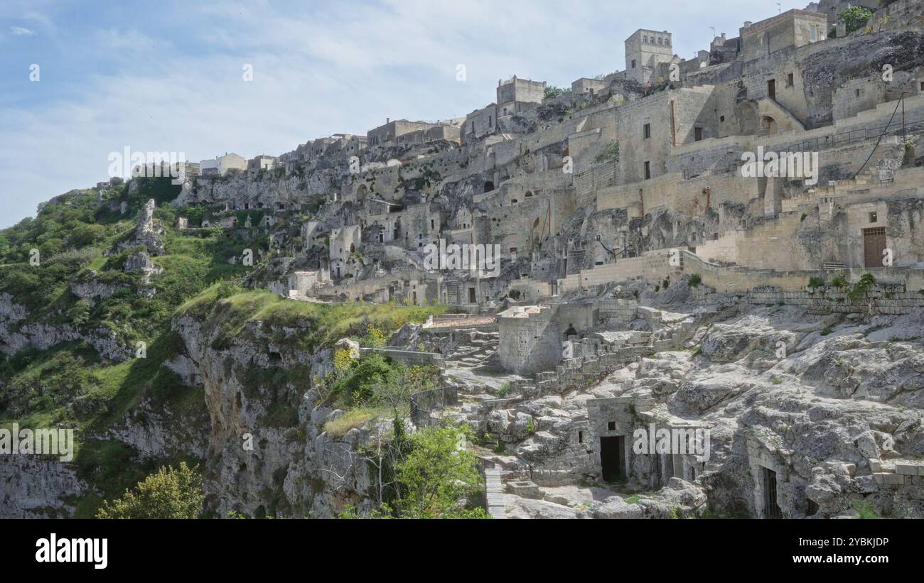 Ancient stone buildings and dwellings on a rugged hillside under a blue ...