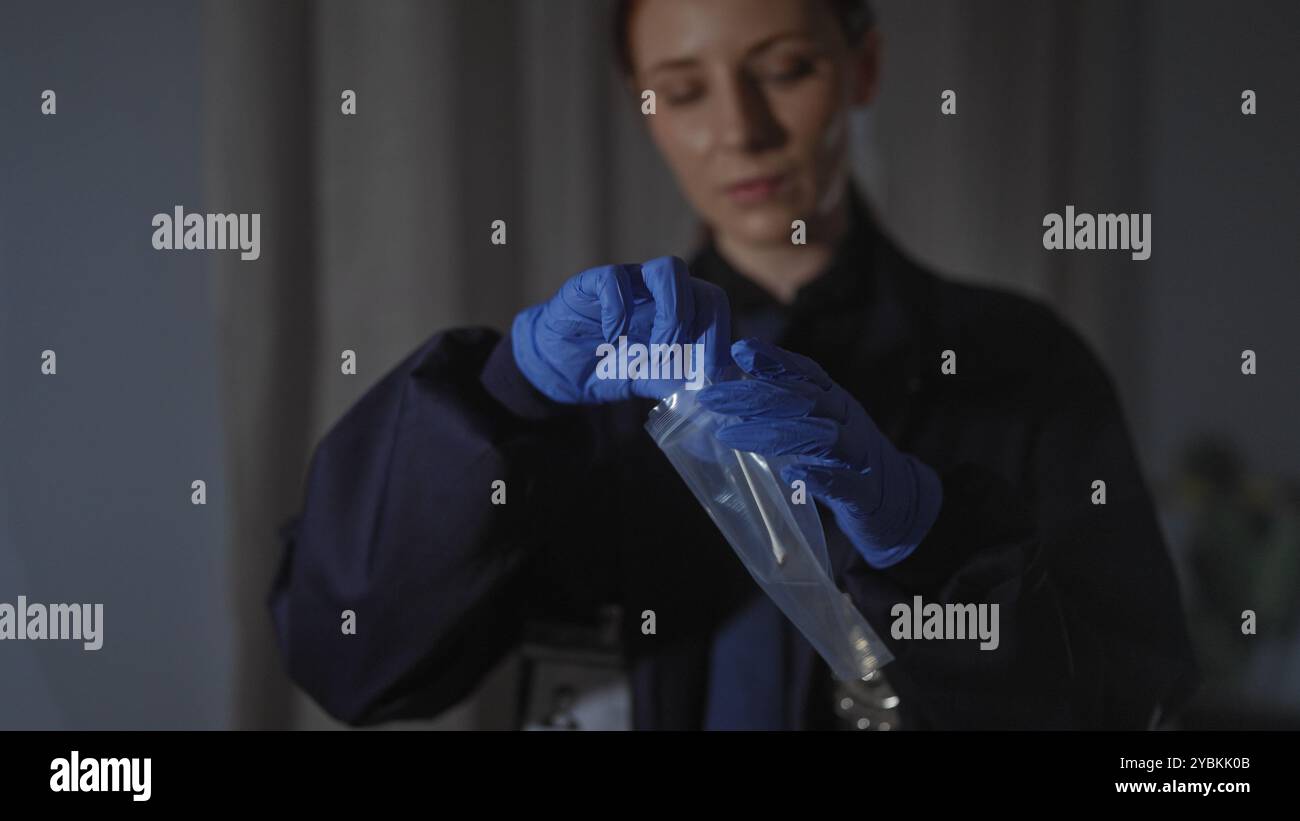 Focused woman in gloves examines evidence at indoor crime scene Stock ...