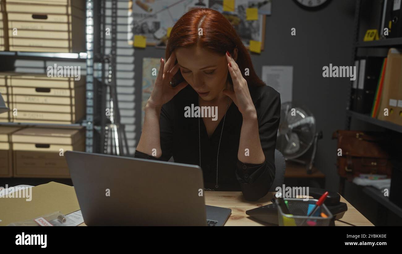 Stressed redhead woman in a detective office with laptop, evidence, and ...