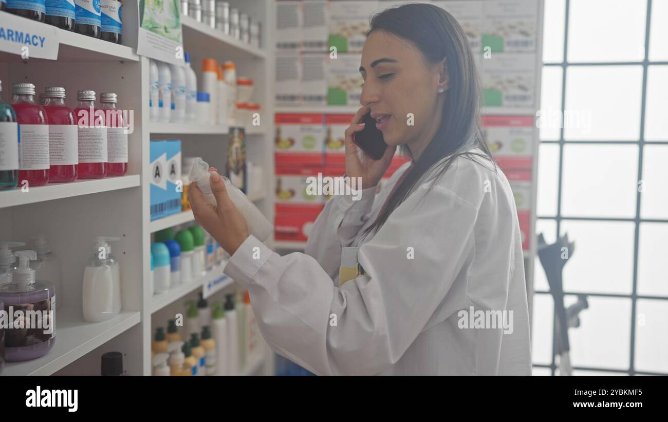 A woman pharmacist multitasks in a drugstore, talking on phone while ...