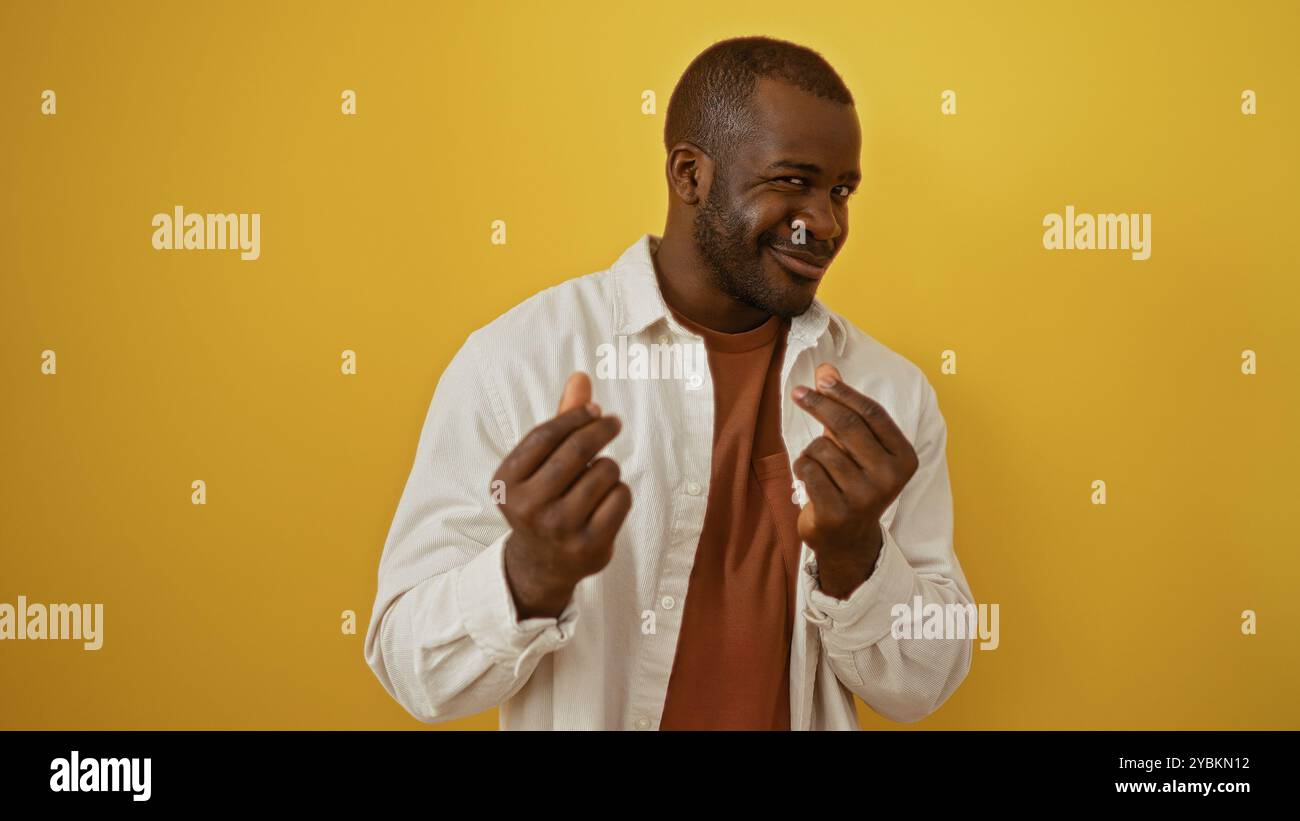 Young man making a money gesture with his hands over an isolated yellow ...