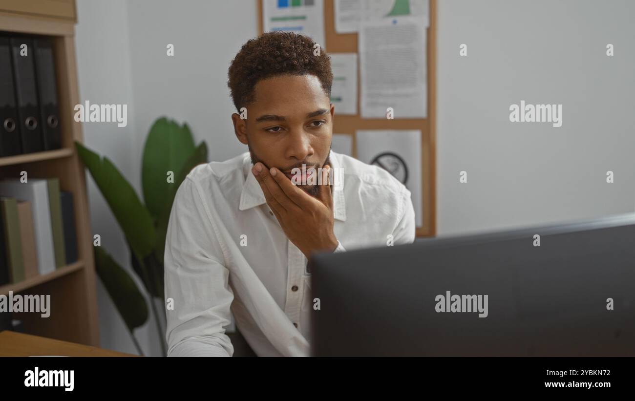 Young man concentrating in an office environment with paperwork on a ...
