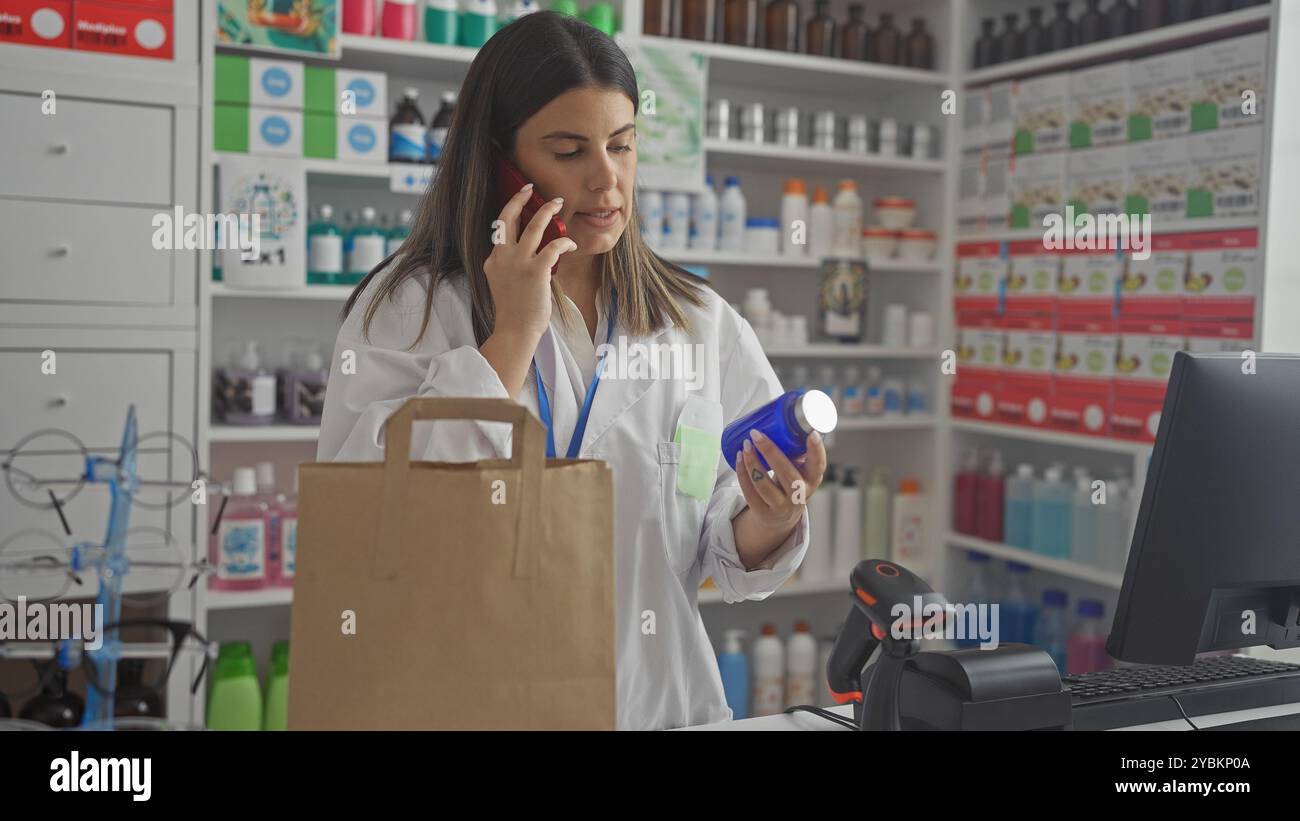 A female pharmacist examines medication while talking on the phone in ...