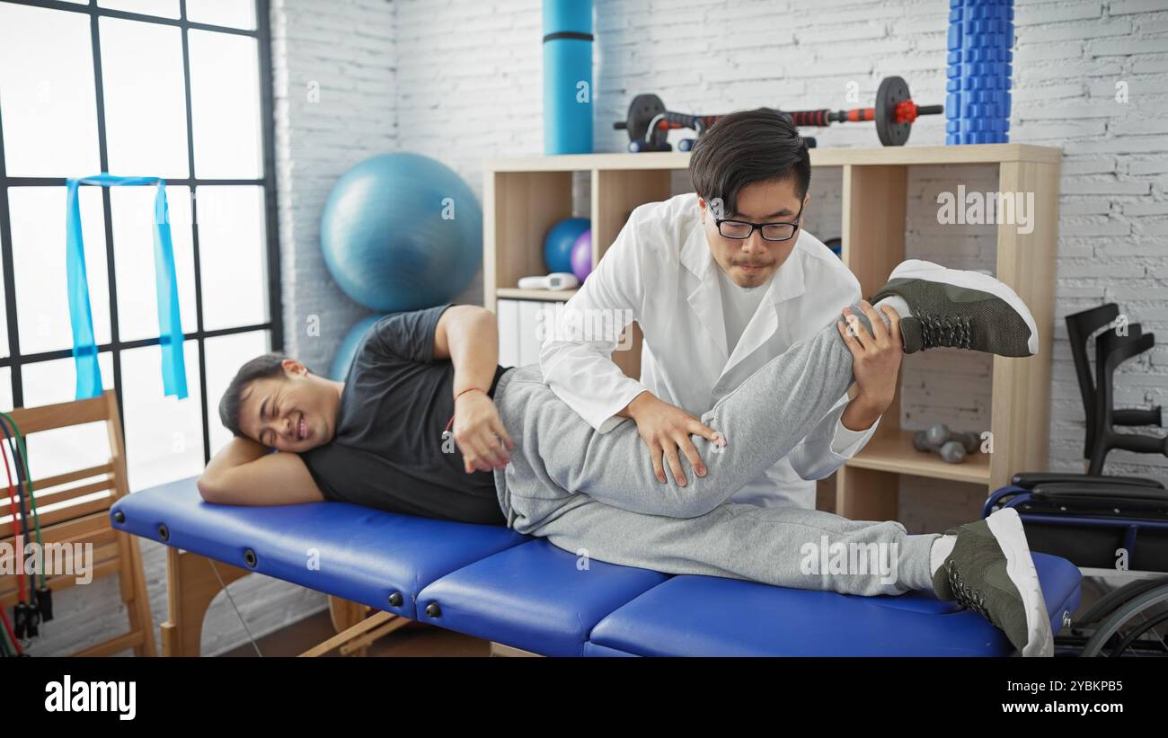 Physiotherapist male assisting another man doing leg exercise in a well ...