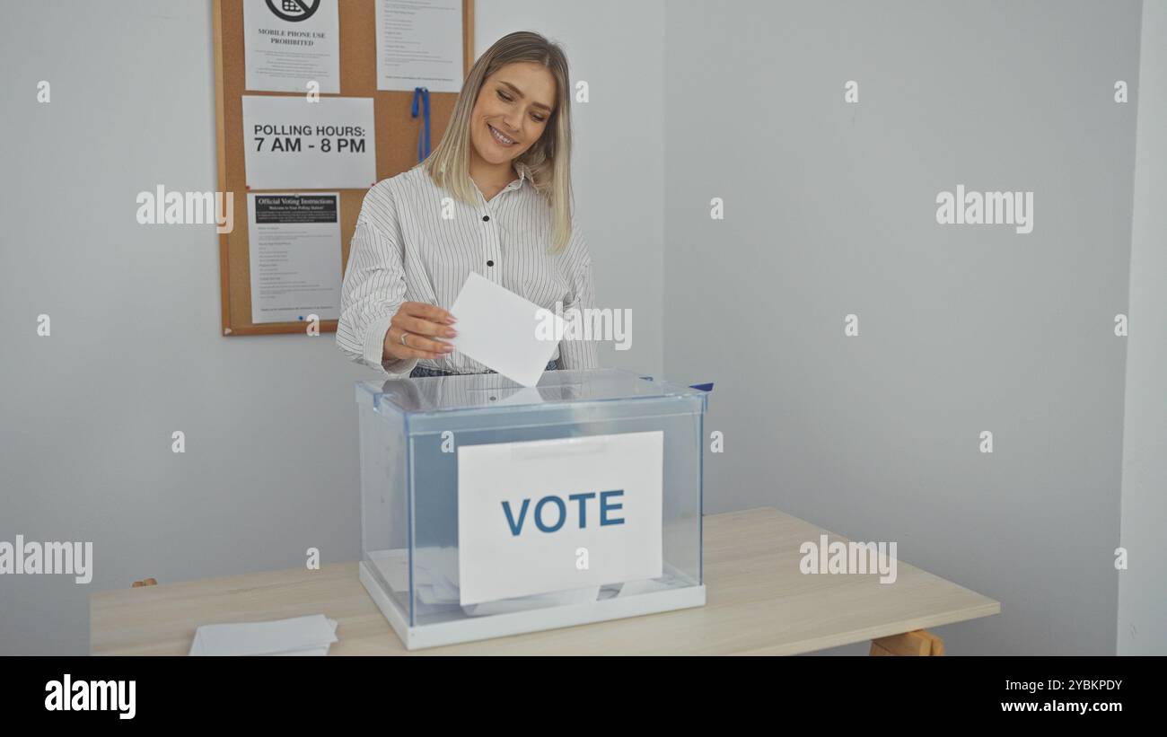 A young, attractive blonde woman is voting in an indoor electoral ...