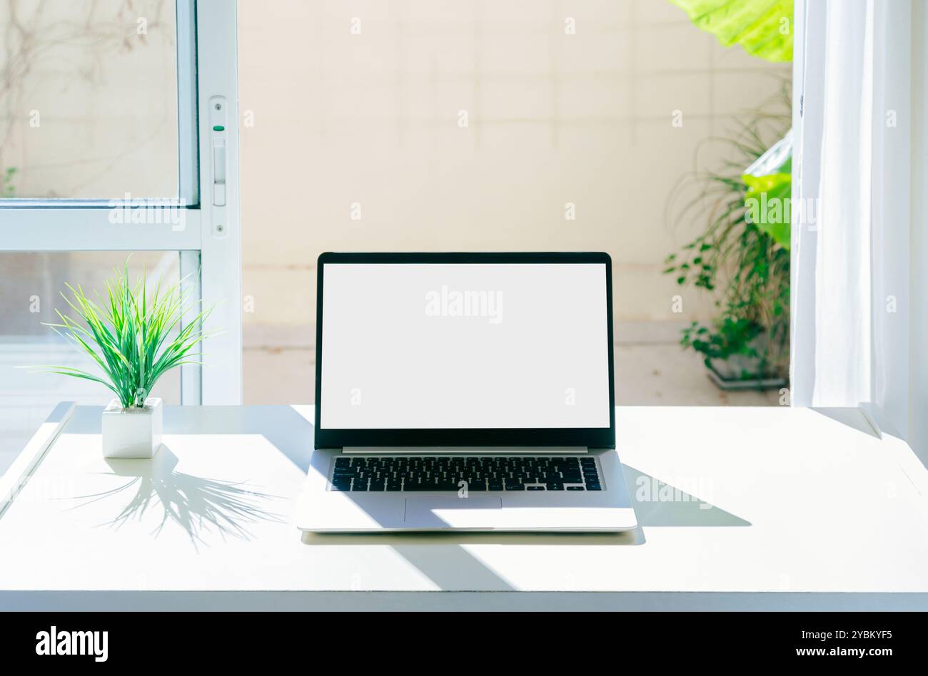 Laptop on a desk with white screen for mockup. There are no people on ...