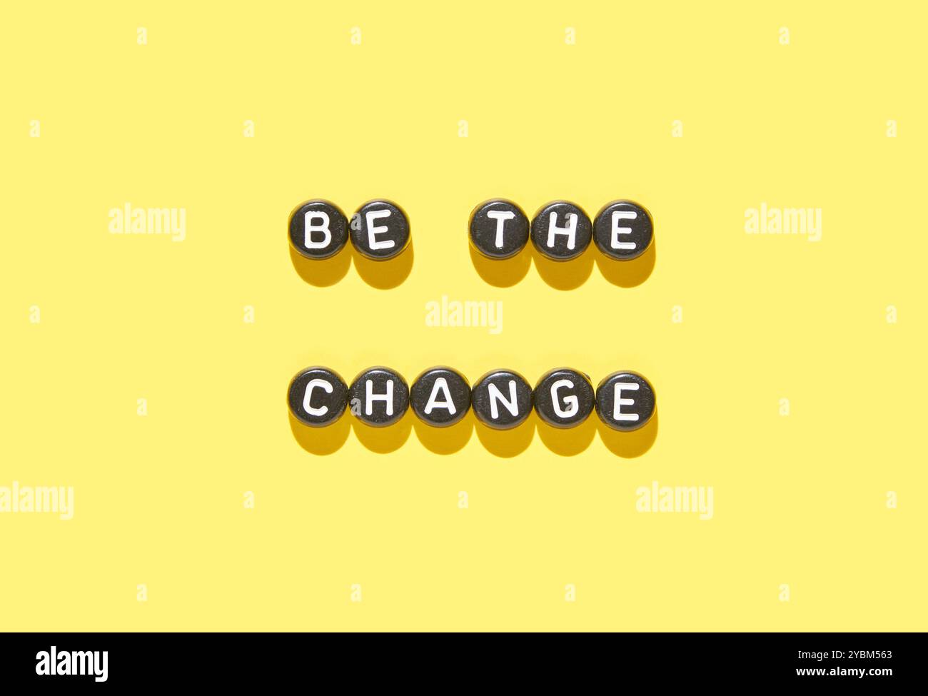 Inspirational message be the change on bright yellow background with ...