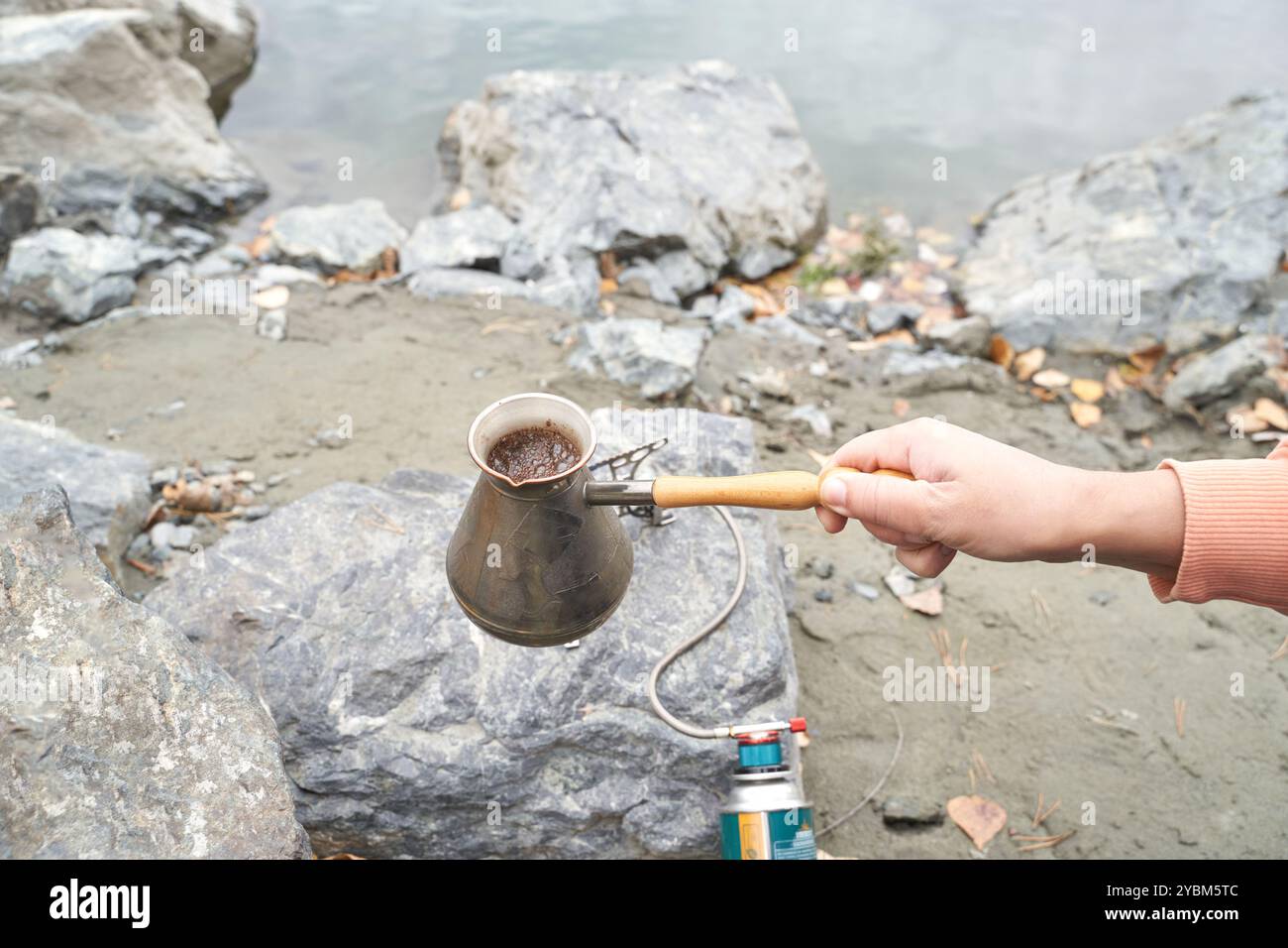 Outdoor coffee brewing by riverbank using traditional pot and camping ...