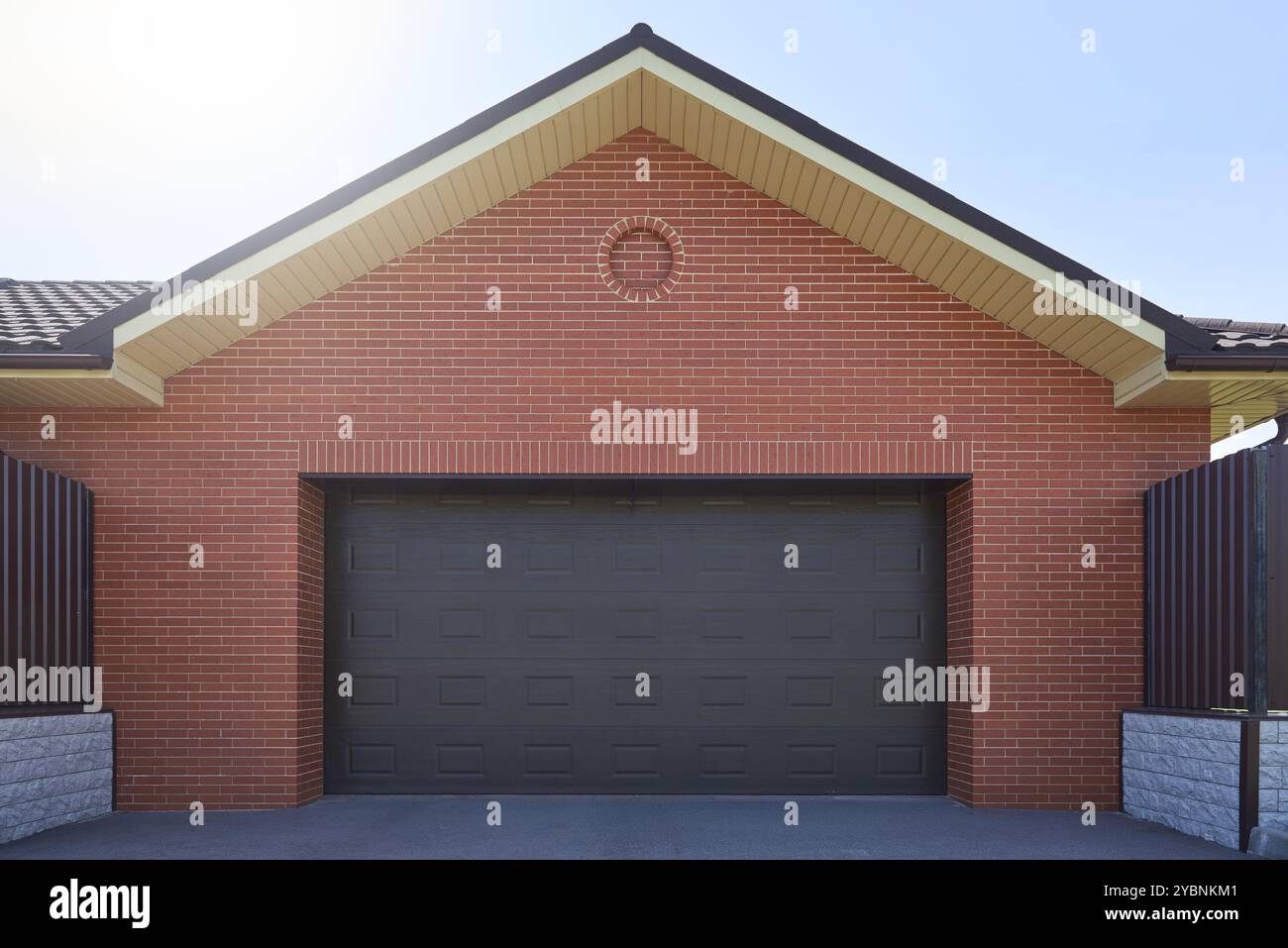 Large and luxurious brick garage with wide automatic gates Stock Photo ...