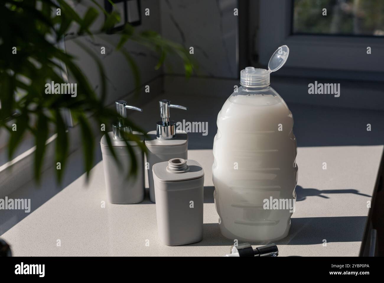 Dispensers and container filled with liquid soap on a countertop in a ...