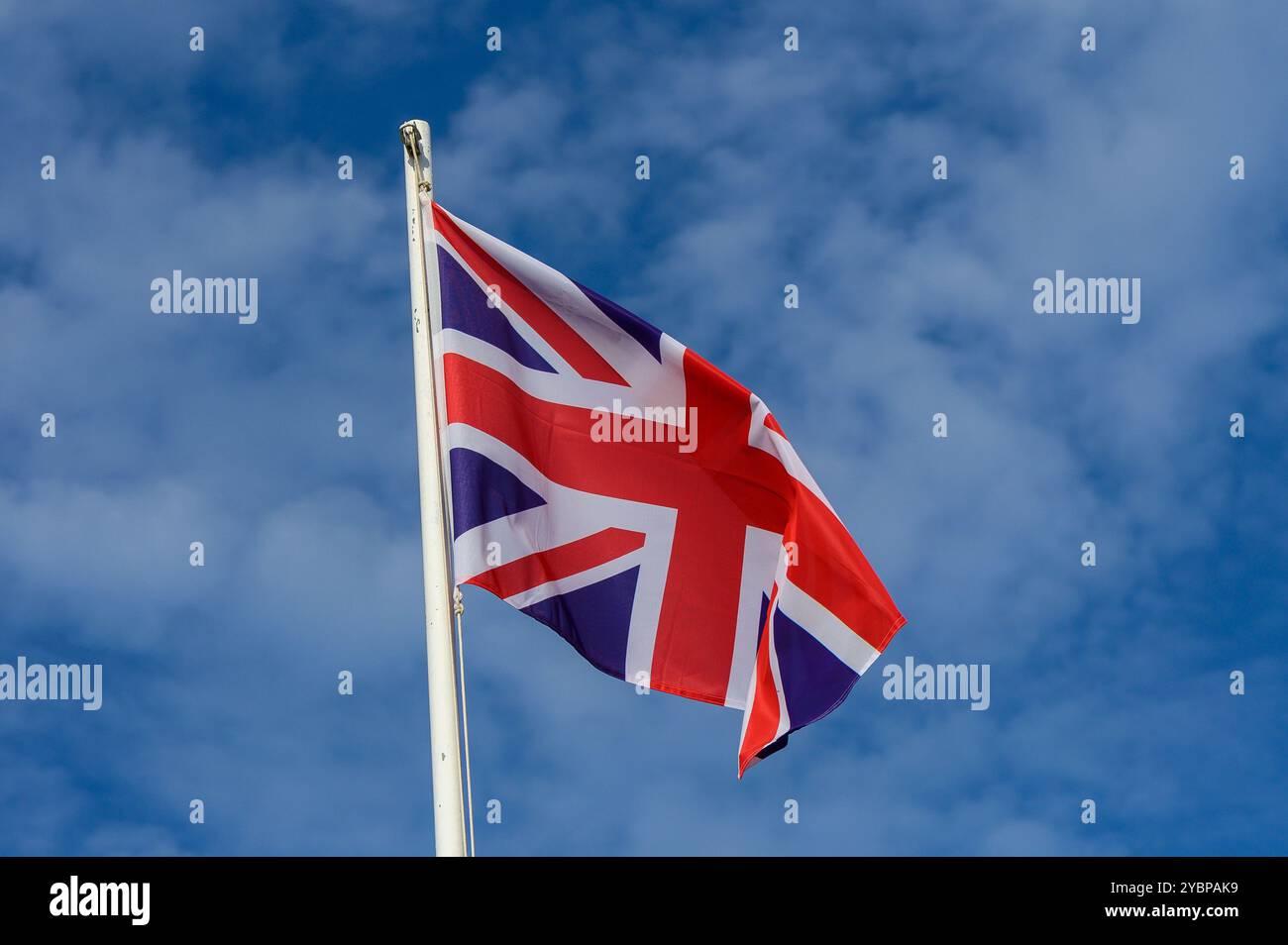 The Union Jack flag flutters gracefully in the breeze, set against a ...