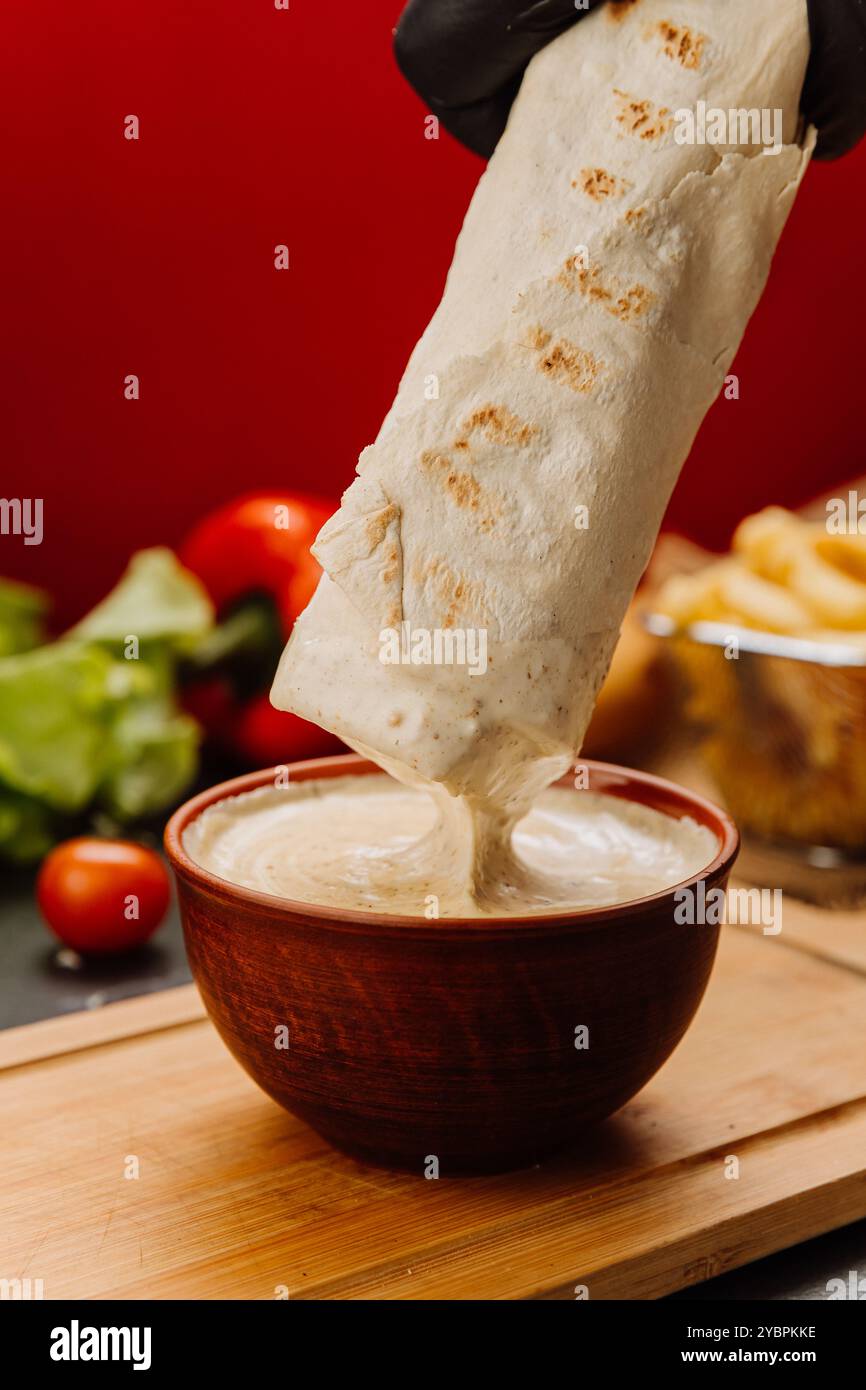 Dipping a wrap into creamy sauce, the perfect blend of flavors for food ...