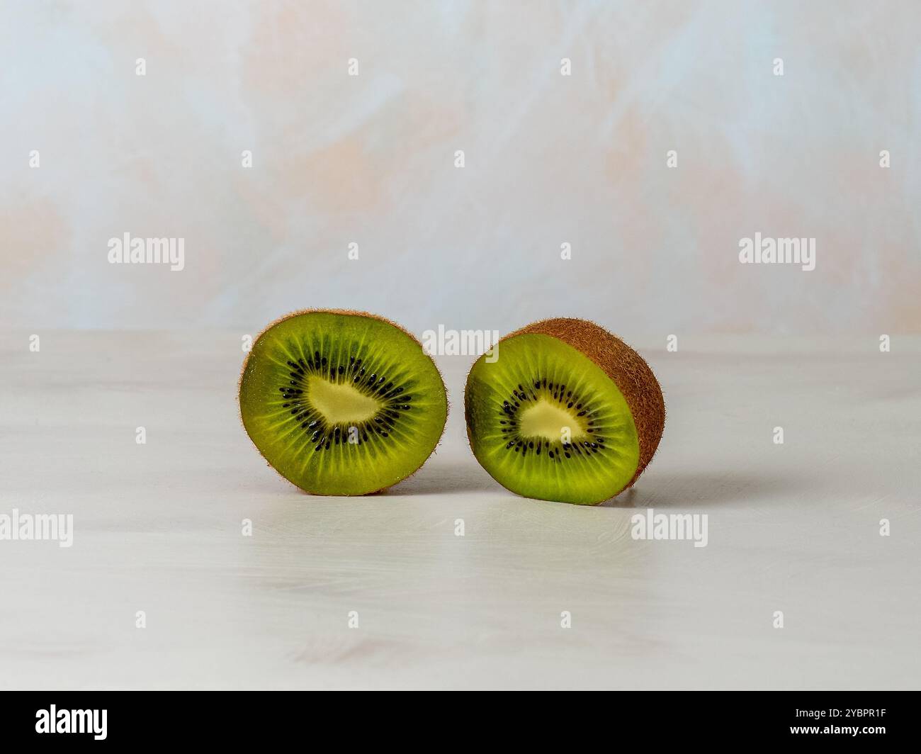 two kiwis cut in half, light background, green fruit, lots of vitamins ...