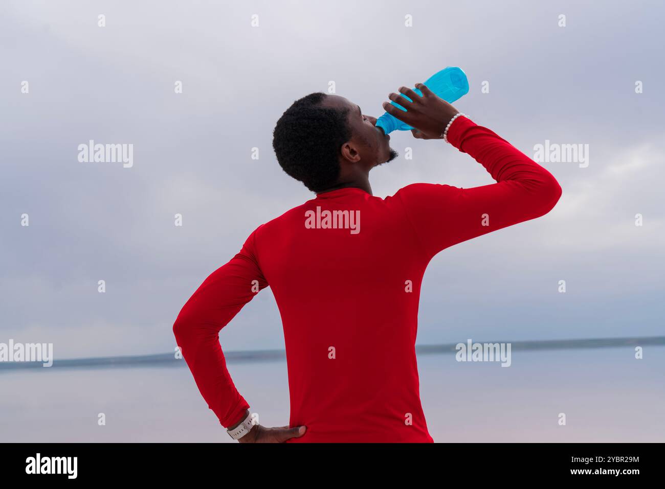 Man Drinking Refreshing Water After Workout At Beach Stock Photo - Alamy