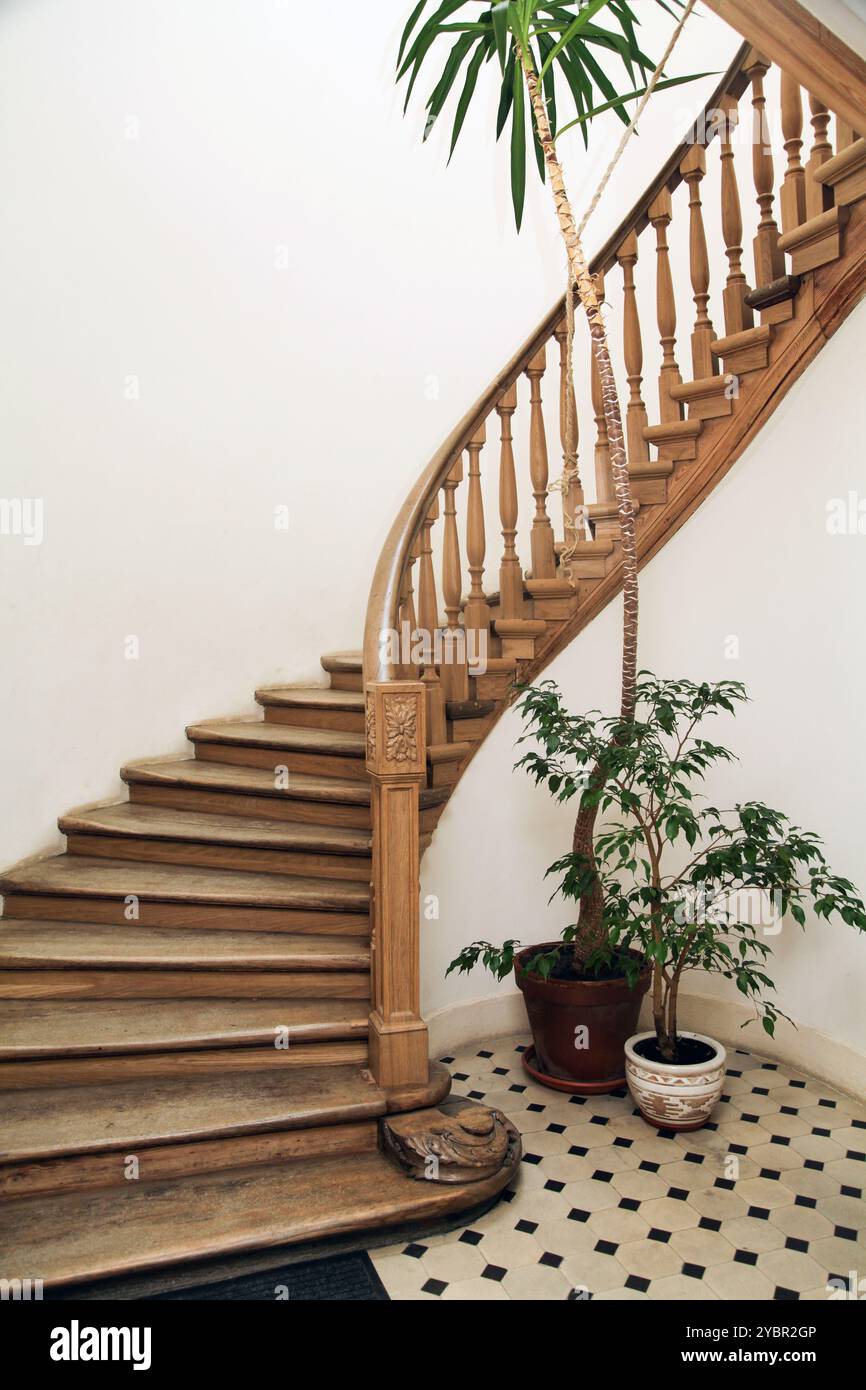 Vintage wooden spiral staircase with banisters and railings in old ...