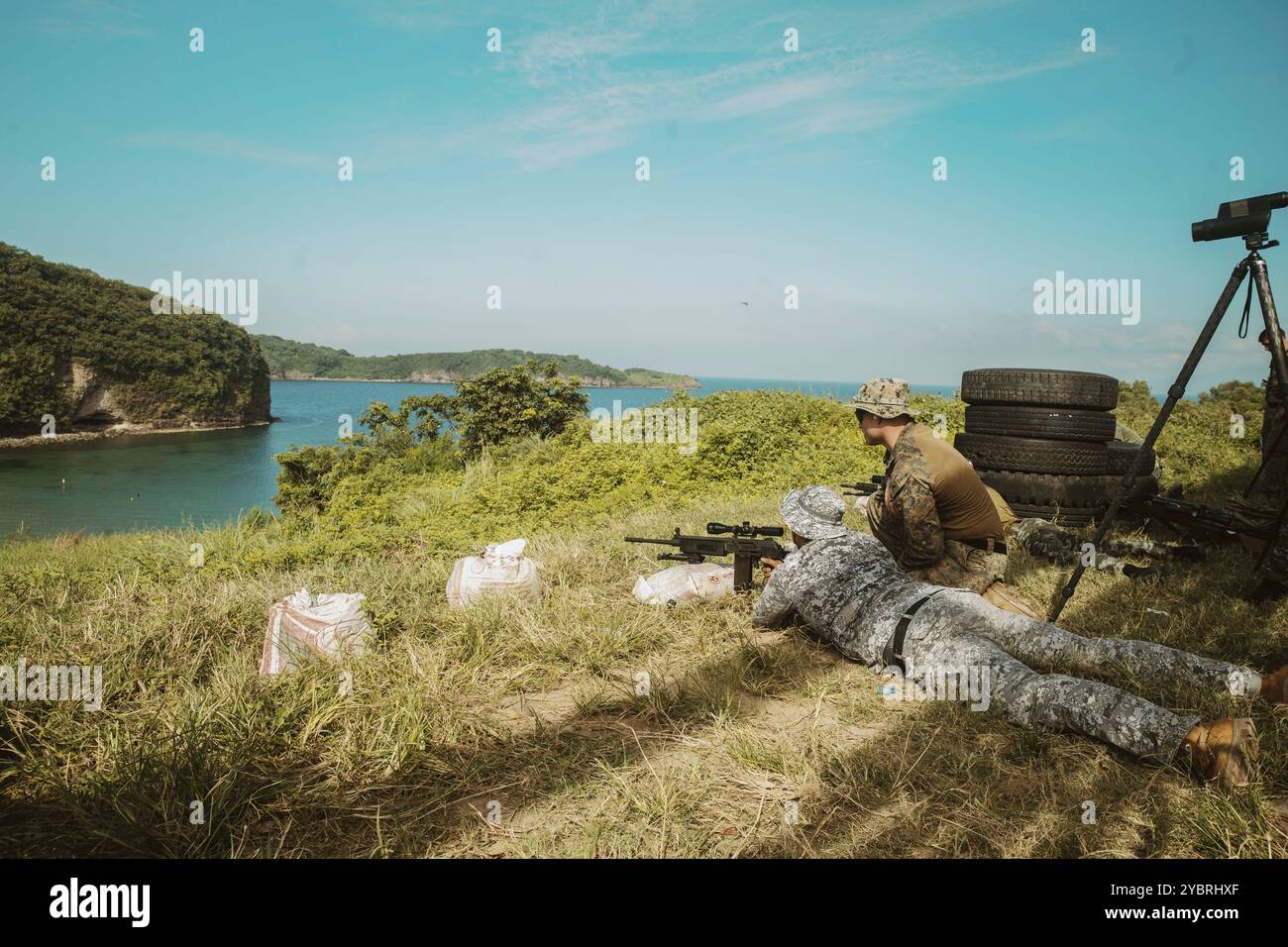 A Philippine coast guardsman, front, fires a rifle to obtain battle sight zero during a live ...