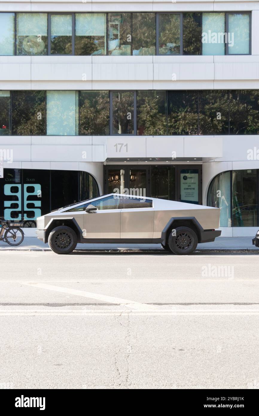 side view of A silver electric EV Tesla Cybertruck parked in the bowery ...