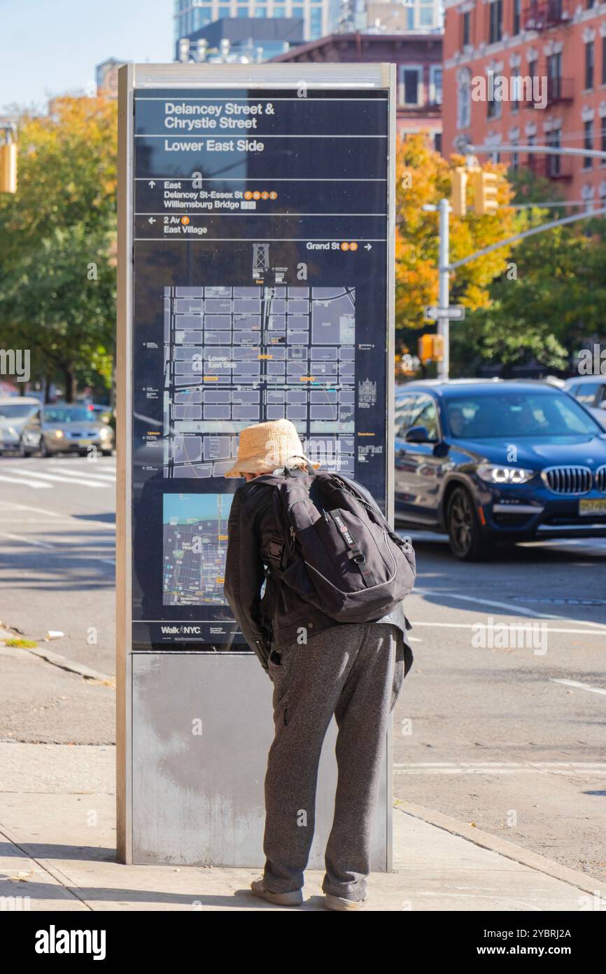 man consults wayfinding map on sign lower east side L.E.S New York City ...