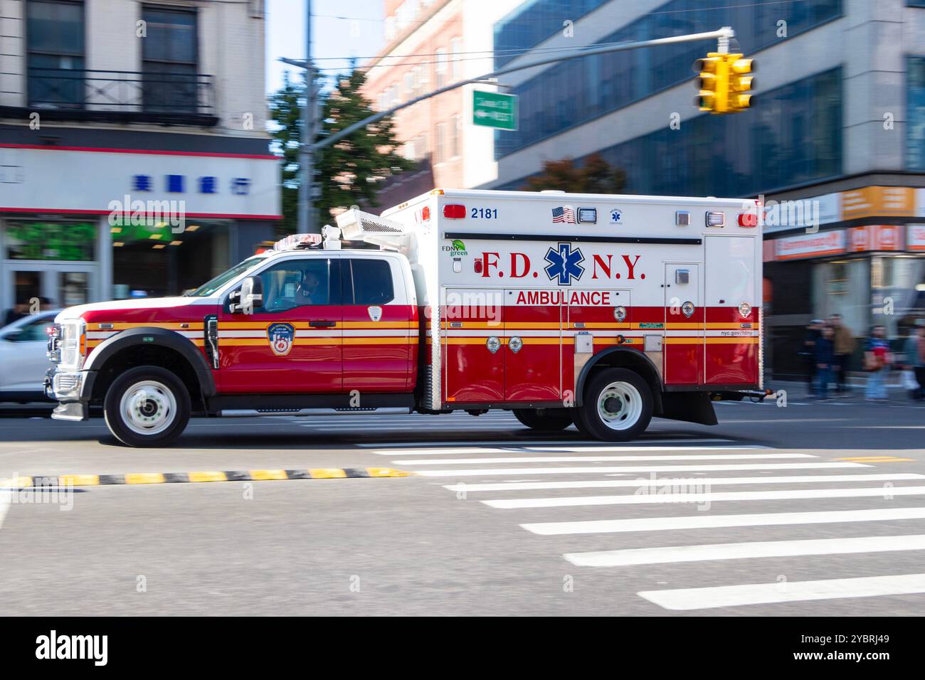 FDNY ambulance speeding through downtown city intersection on a sunny ...