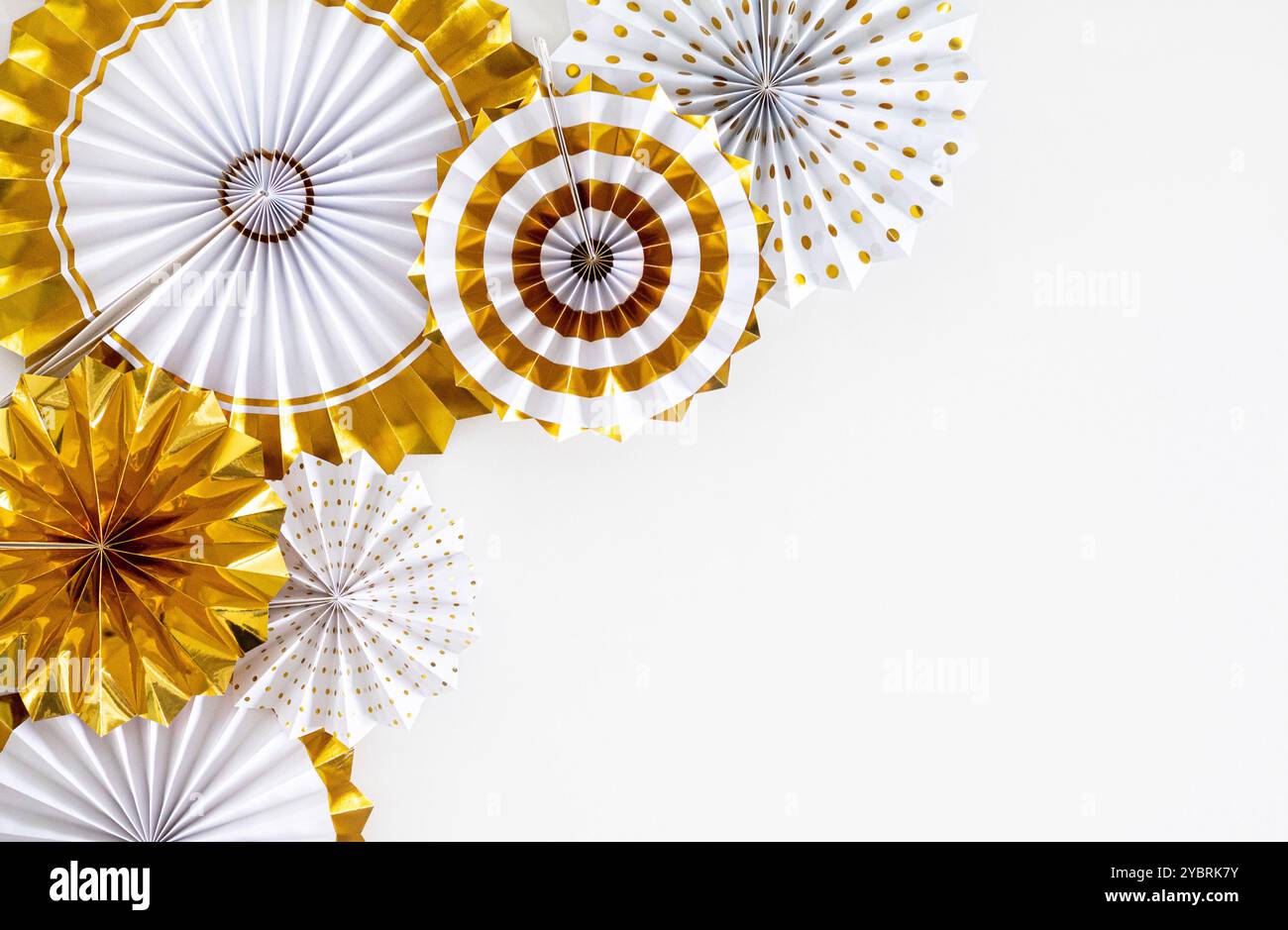 Tissue gold paper fans and honeycombs on the white background. Holiday ...
