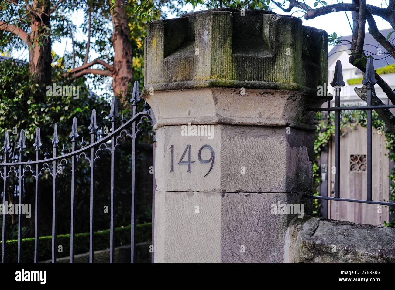 Crenellated cap sandstone gate post and iron palisade fence with cast ...