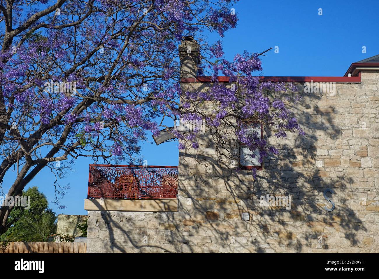 Sandstone house, side wall windows verdant and decorative iron lace at ...