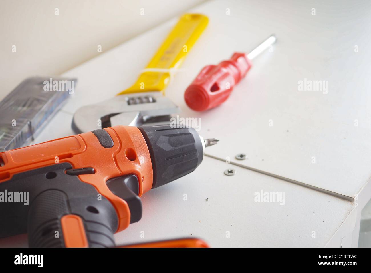 DIY tools and materials are arranged on a wooden floor, illuminated by ...